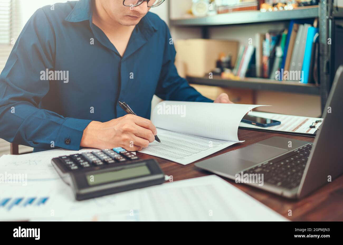 Accounting woking with data sheet on the office desk. Calculator with ...