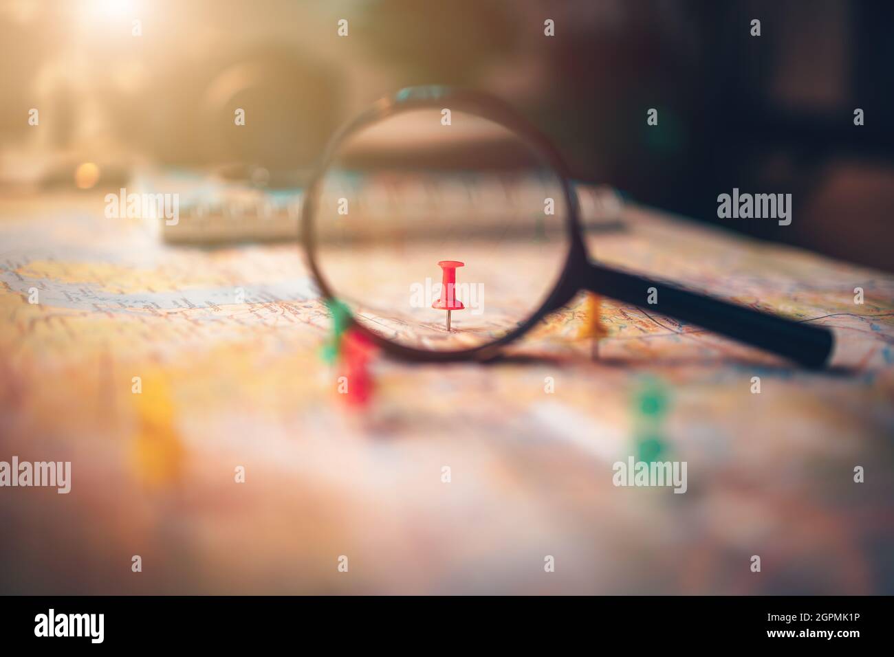 A magnifying glass with pins pinned on the map. pushpin showing the ...