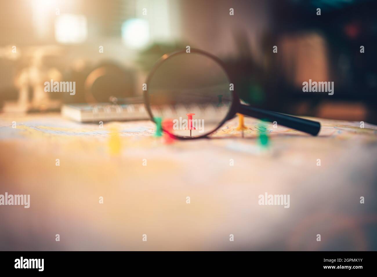 A magnifying glass with pins pinned on the map. pushpin showing the ...