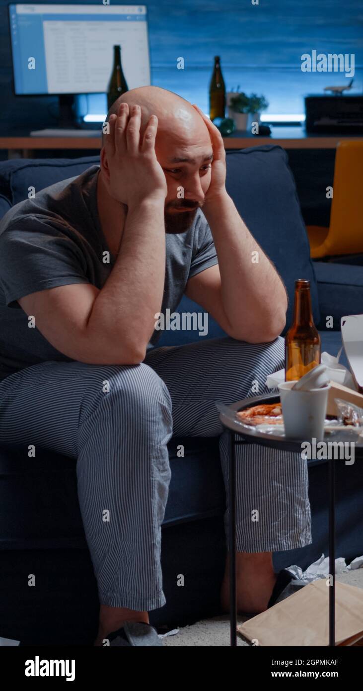 Exhausted frustrated depressed young man massaging temples having ...