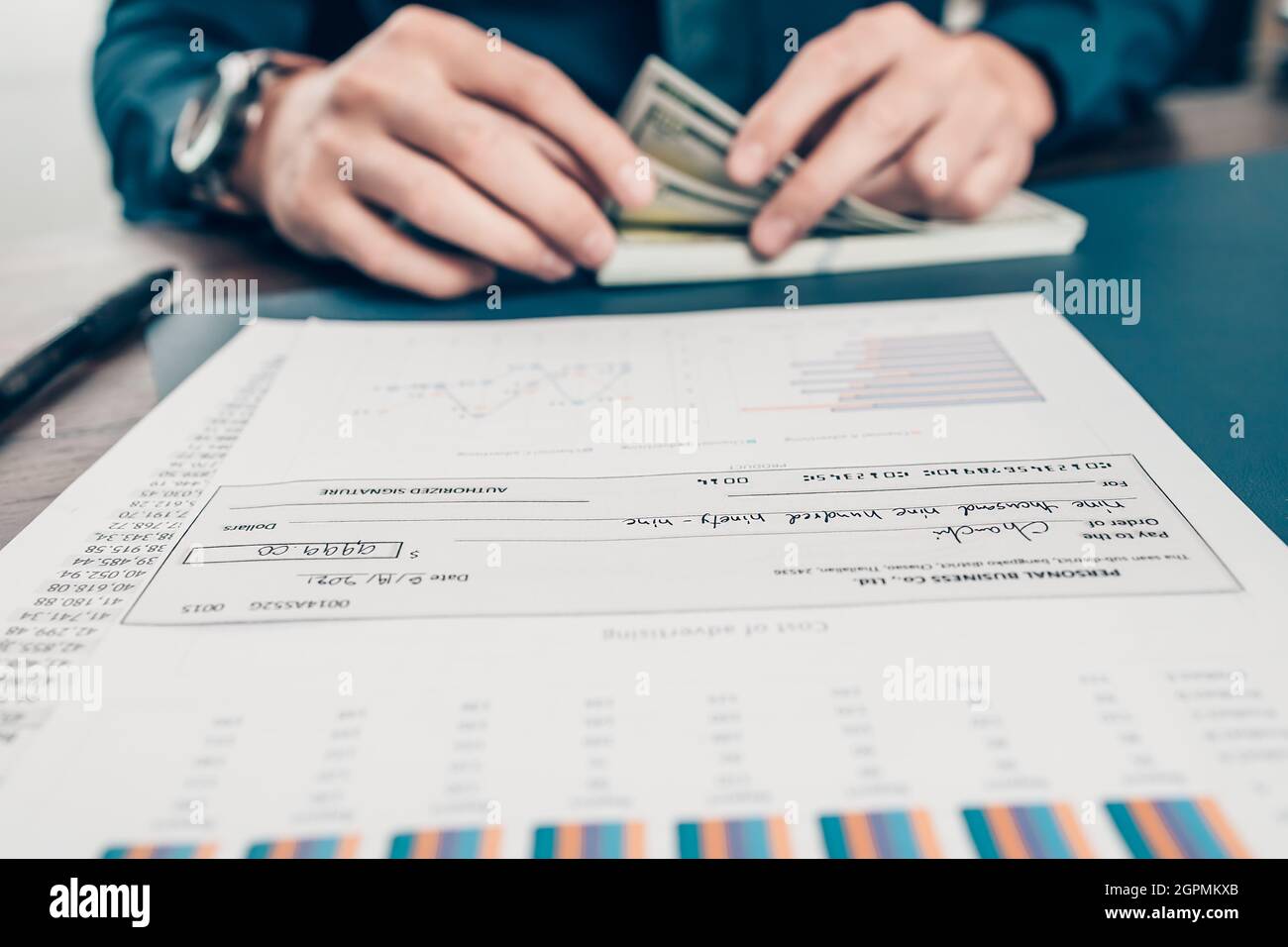 Business man hand writing and signing white blank bank check book and ...