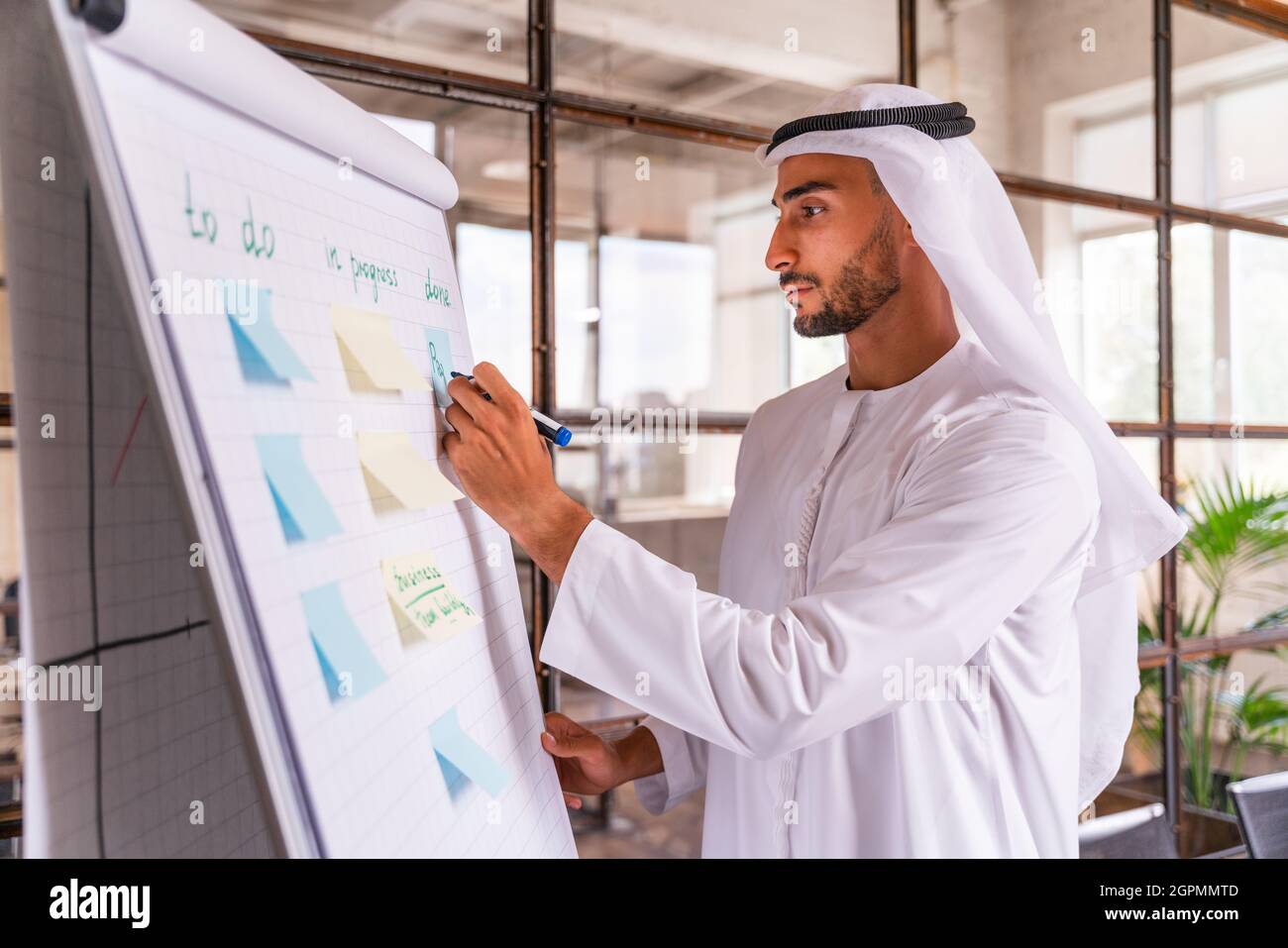 Arab businessman wearing traditional emirates kandura at work in a ...