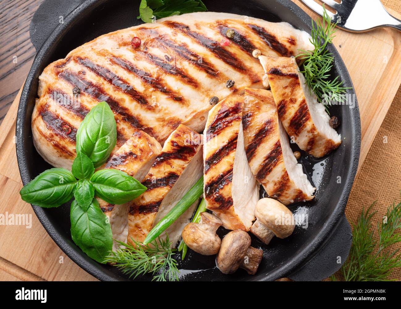 Roasted chicken fillet and mushrooms with herb in the frying pan on the ...