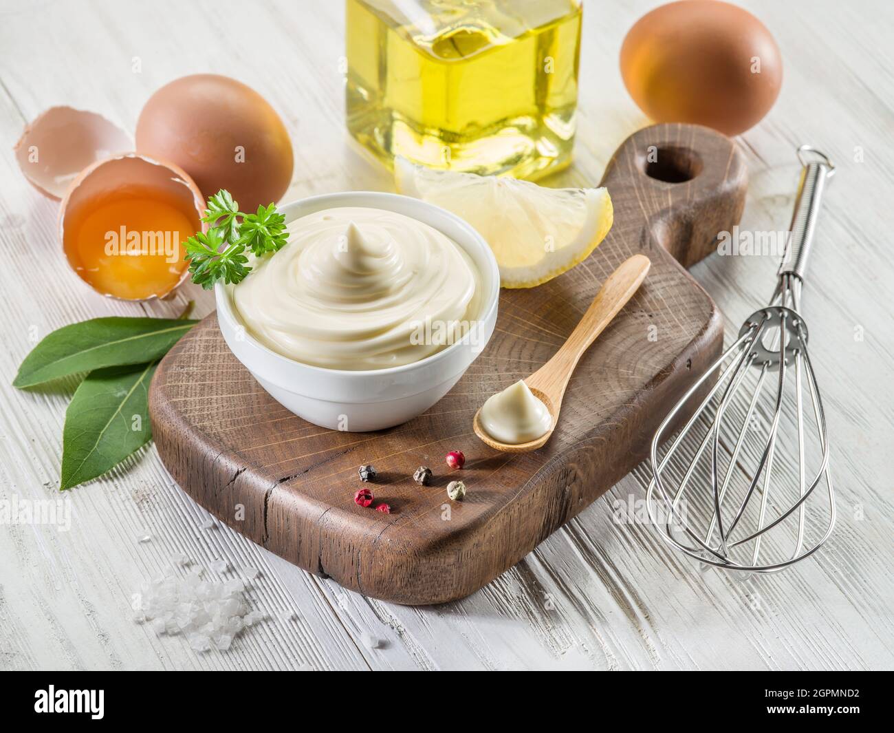 Bowl with mayonnaise sauce in the centre and mayonnaise ingredients ...