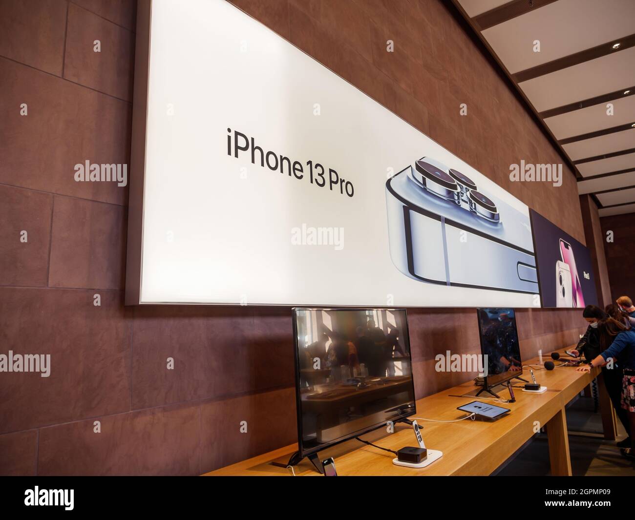 ustomers under large poster of iPhone 13 Pro at the Apple Store as ...