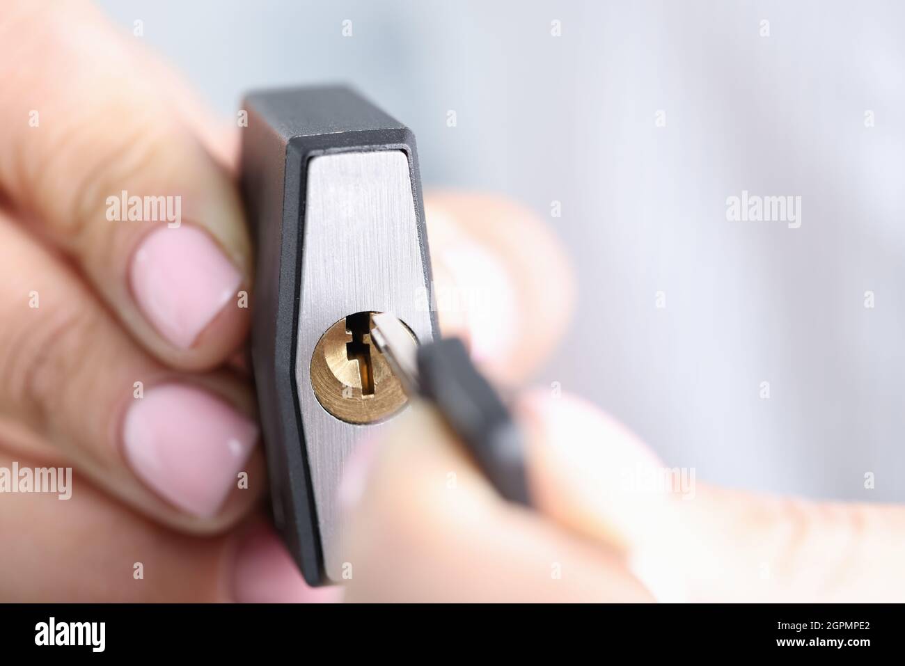 Female hand holds key and lock closeup Stock Photo - Alamy