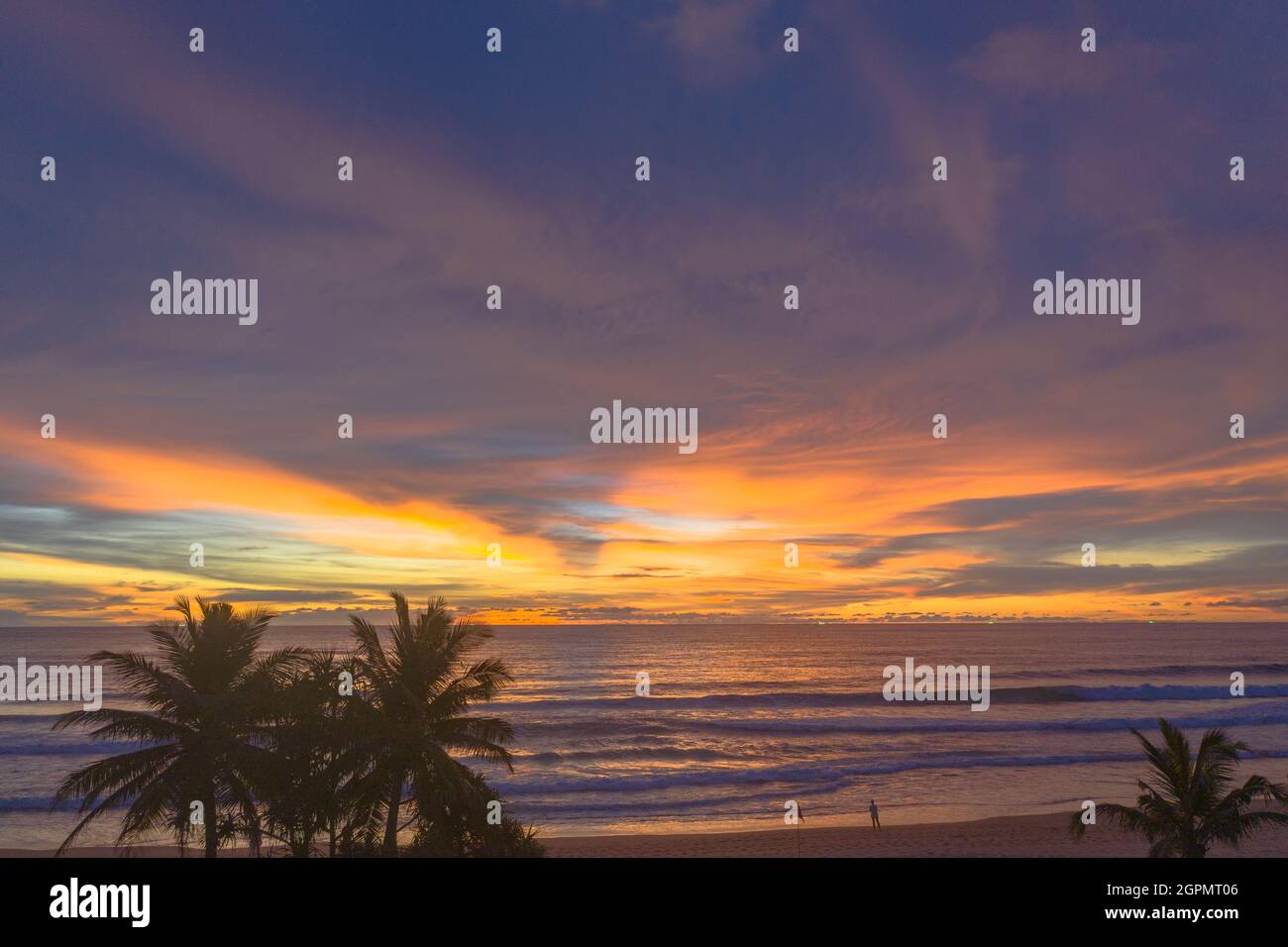 the colorful clouds are changing color in sky at sunset above the sea ...