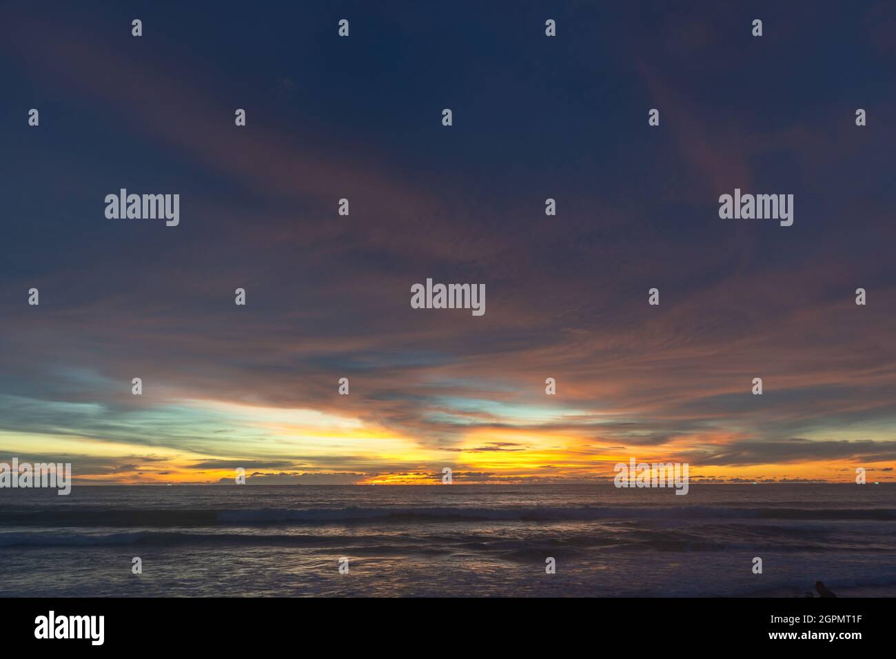 the colorful clouds are changing color in sky at sunset above the sea ...