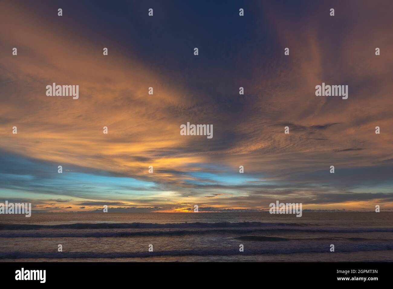 the colorful clouds are changing color in sky at sunset above the sea ...