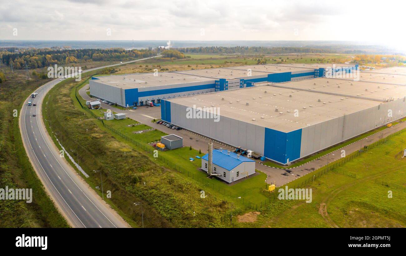 Aerial shot of industrial warehouse. Loading hub and many trucks with ...