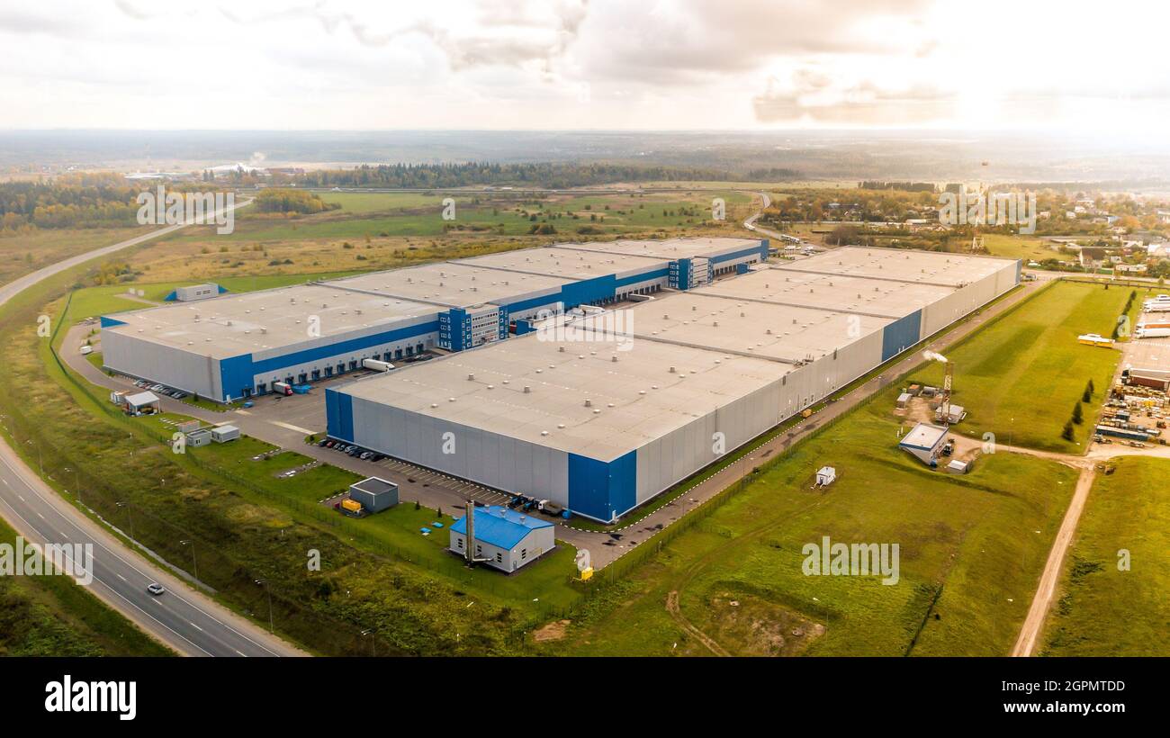 Aerial shot of industrial warehouse. Loading hub and many trucks with ...