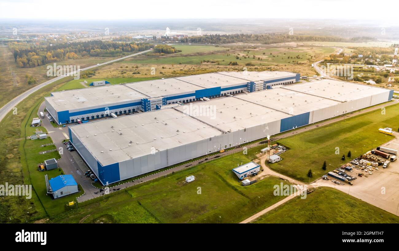 Aerial shot of industrial warehouse. Loading hub and many trucks with ...