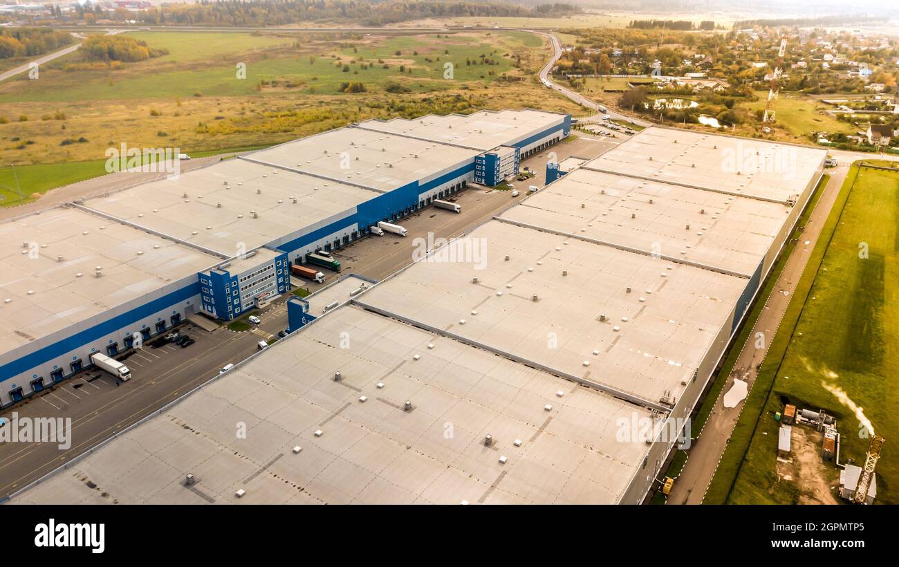Aerial shot of industrial warehouse. Loading hub and many trucks with ...