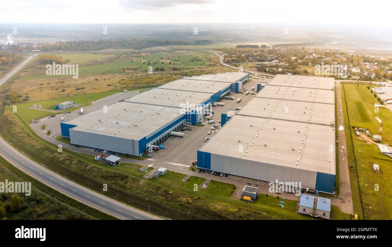 Aerial shot of industrial warehouse. Loading hub and many trucks with ...