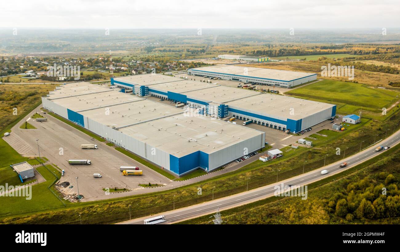 Aerial shot of industrial warehouse. Loading hub and many trucks with ...