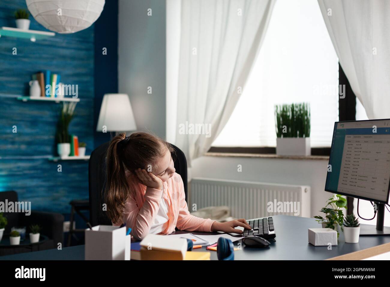 Tired exhausted schoolgirl doing mathematics homework analyzing online ...