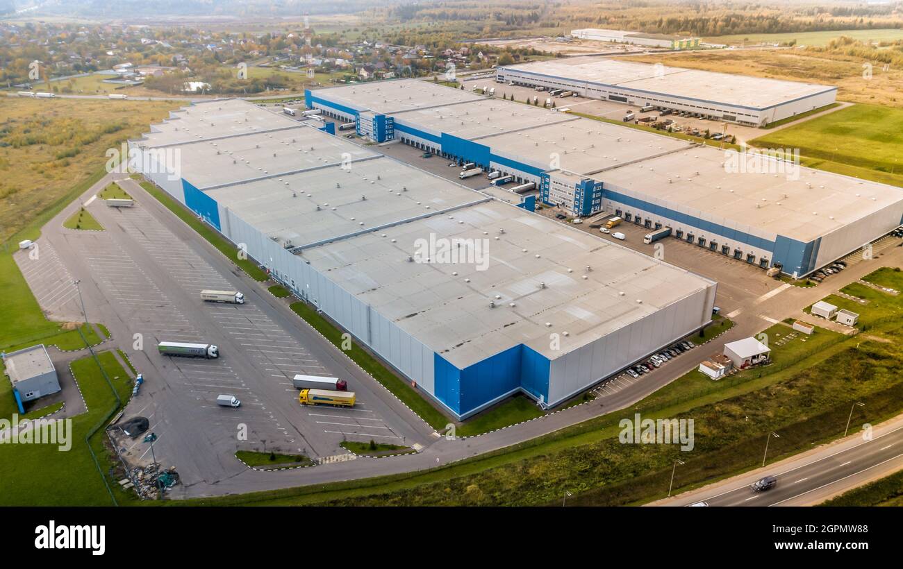 Aerial shot of industrial warehouse. Loading hub and many trucks with ...