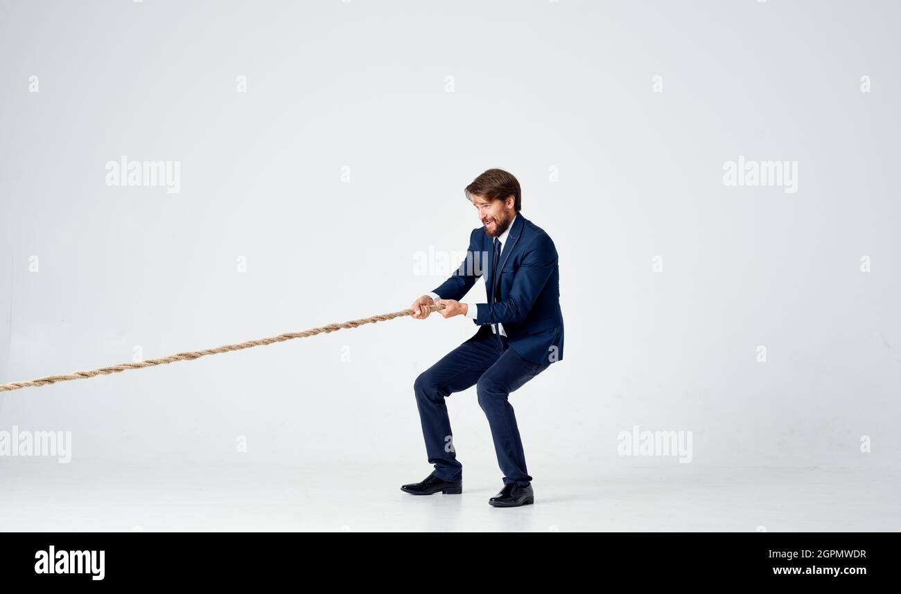 business man in suit pulling rope Studio team work Stock Photo - Alamy