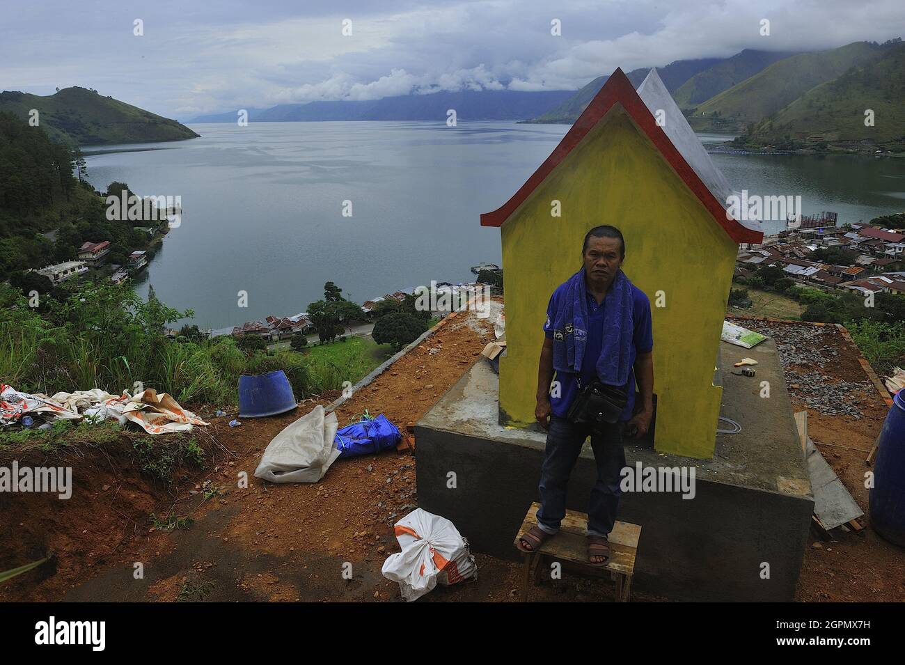 Kasner Sagala, 53, seen on portrait at his father grave with the ...