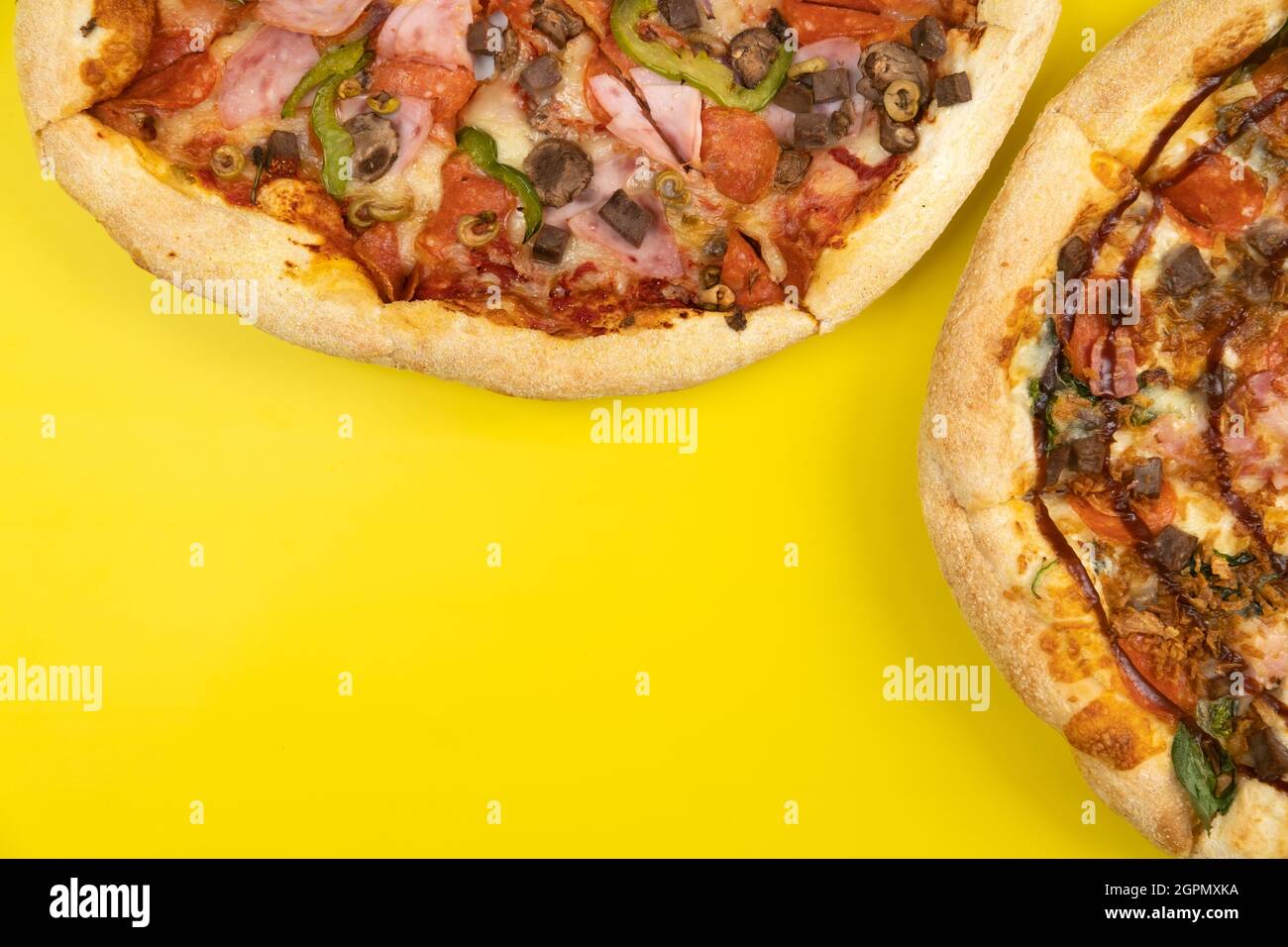 Two different Delicious big pizzas on a yellow background Stock Photo ...