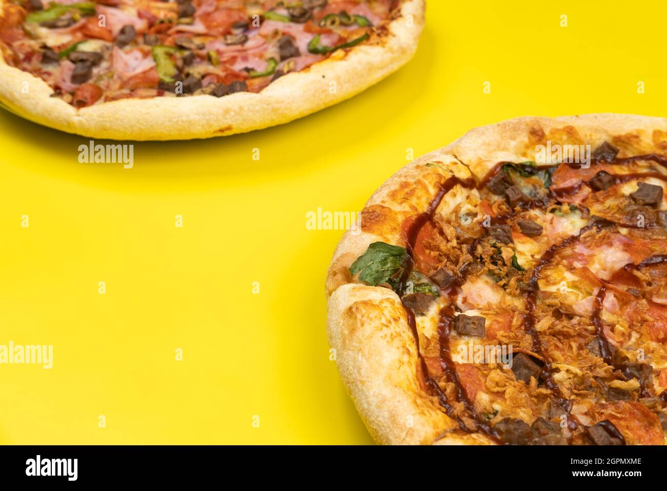 Two different Delicious big pizzas on a yellow background Stock Photo ...