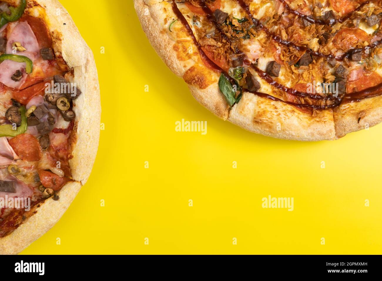 Two different Delicious big pizzas on a yellow background Stock Photo ...