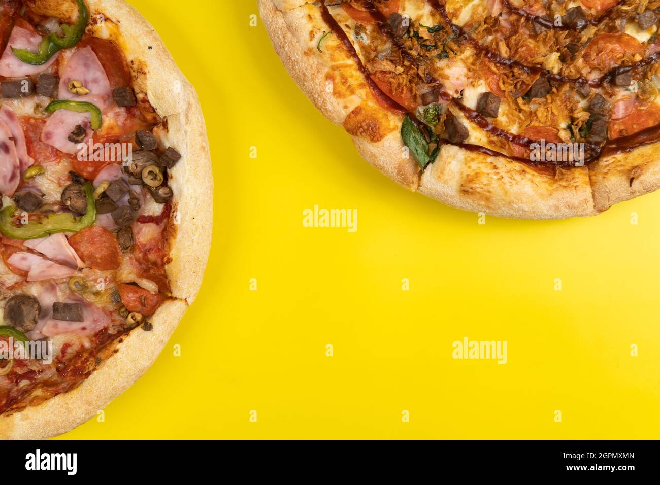 Two different Delicious big pizzas on a yellow background Stock Photo ...