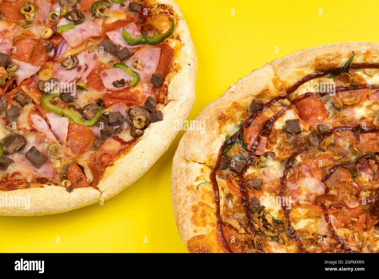 Two different Delicious big pizzas on a yellow background Stock Photo ...
