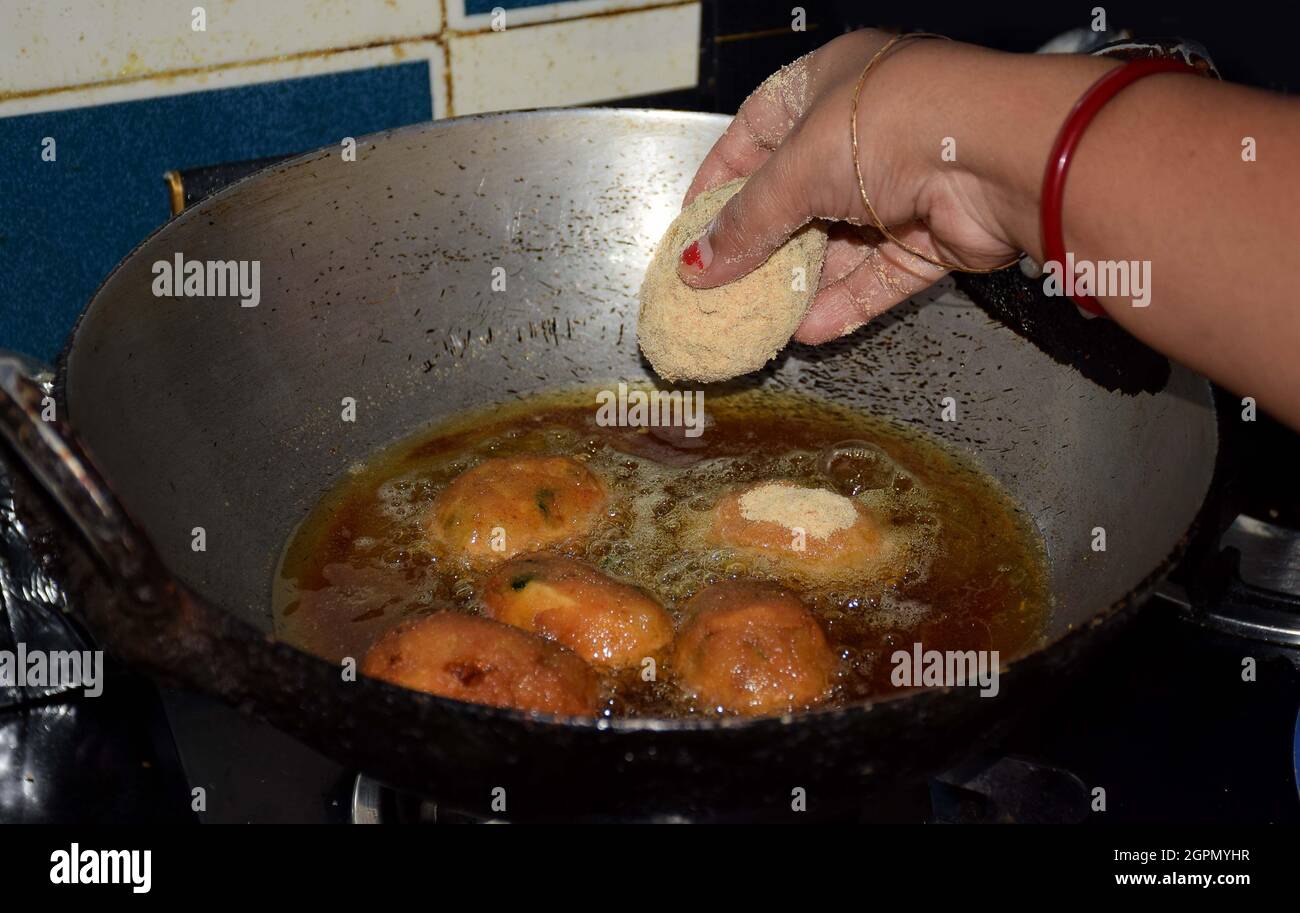 Hand of a lady putting raw egg pakora's in frying pan Stock Photo - Alamy