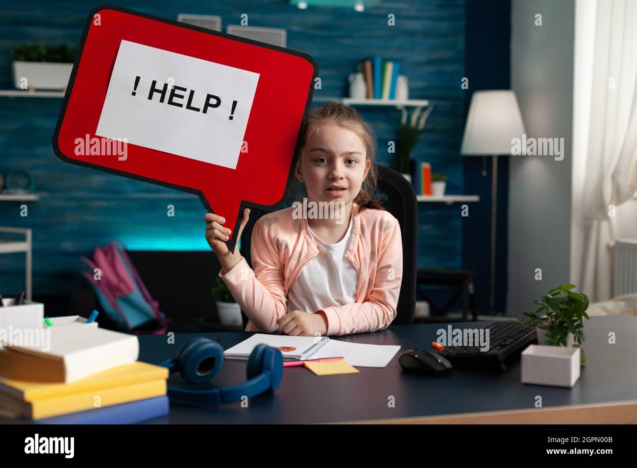 Portrait of little schoolchild holding help banner while attenting at ...