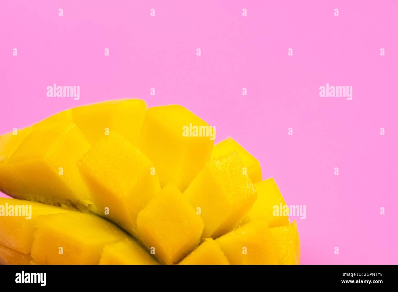Fresh ripe mango on a pink background. Half a sliced mango on a pink ...