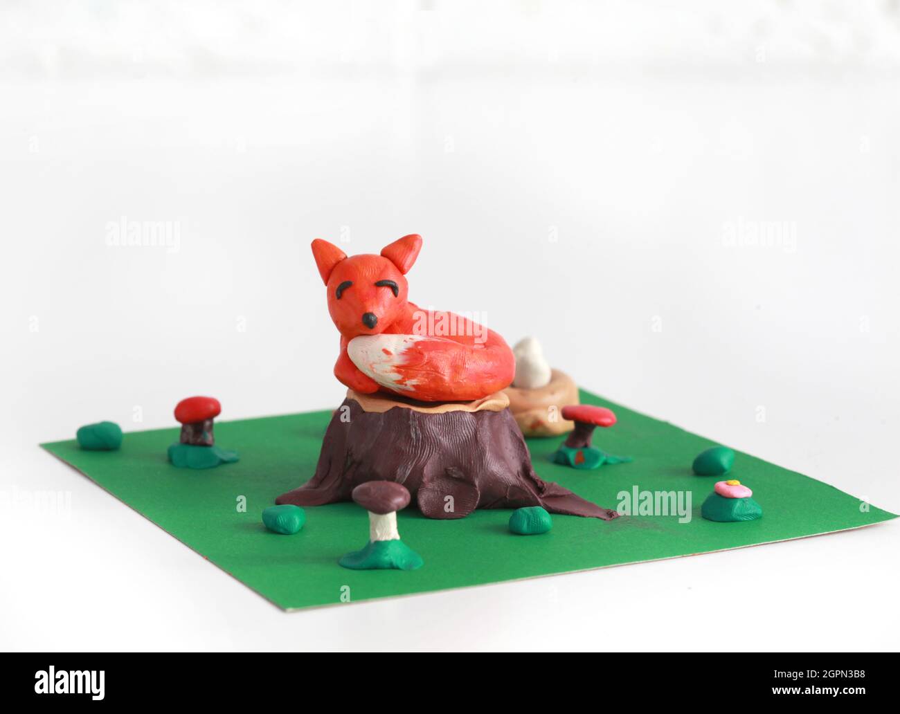 Plasticine world - small sweet red fox lying on a stump Stock Photo - Alamy