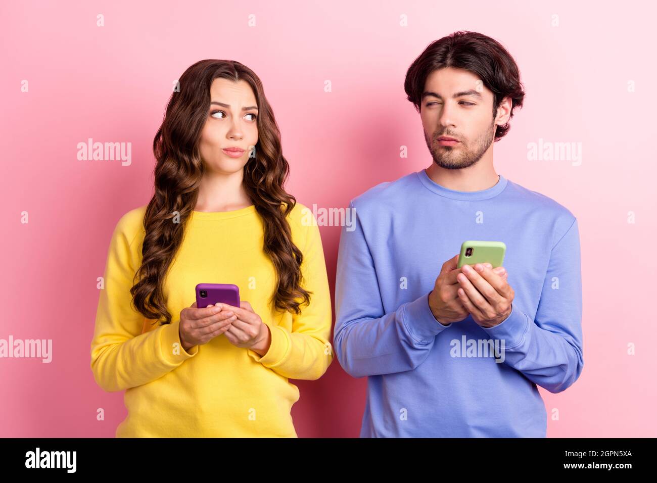 Photo of young couple boyfriend girlfriend hold smartphone suspicious ...