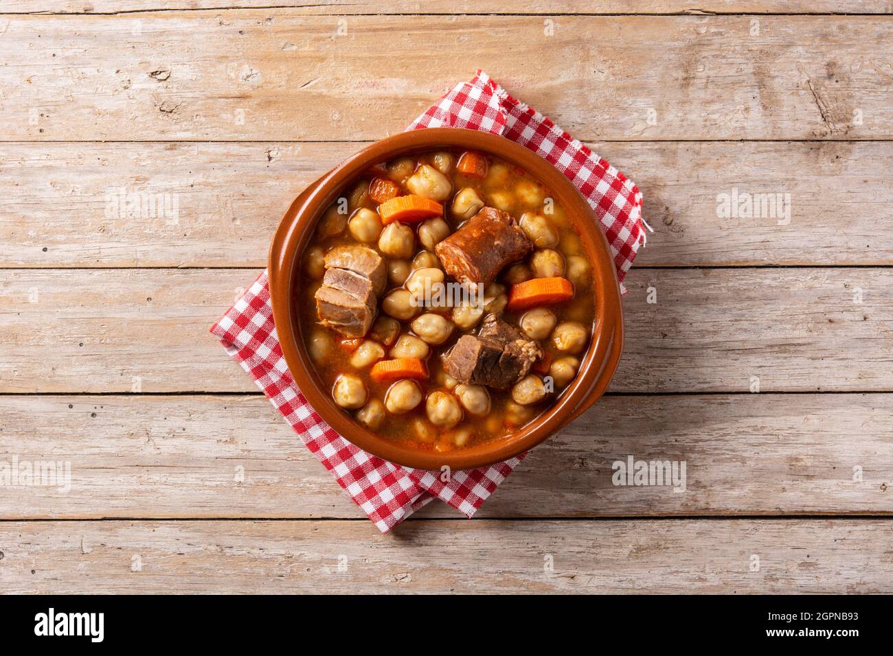 Traditional Spanish cocido madrileño in bowl on wooden table Stock ...