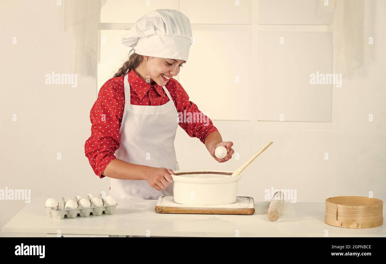 adding the egg. time to eat. happy child cooking in kitchen. bake ...