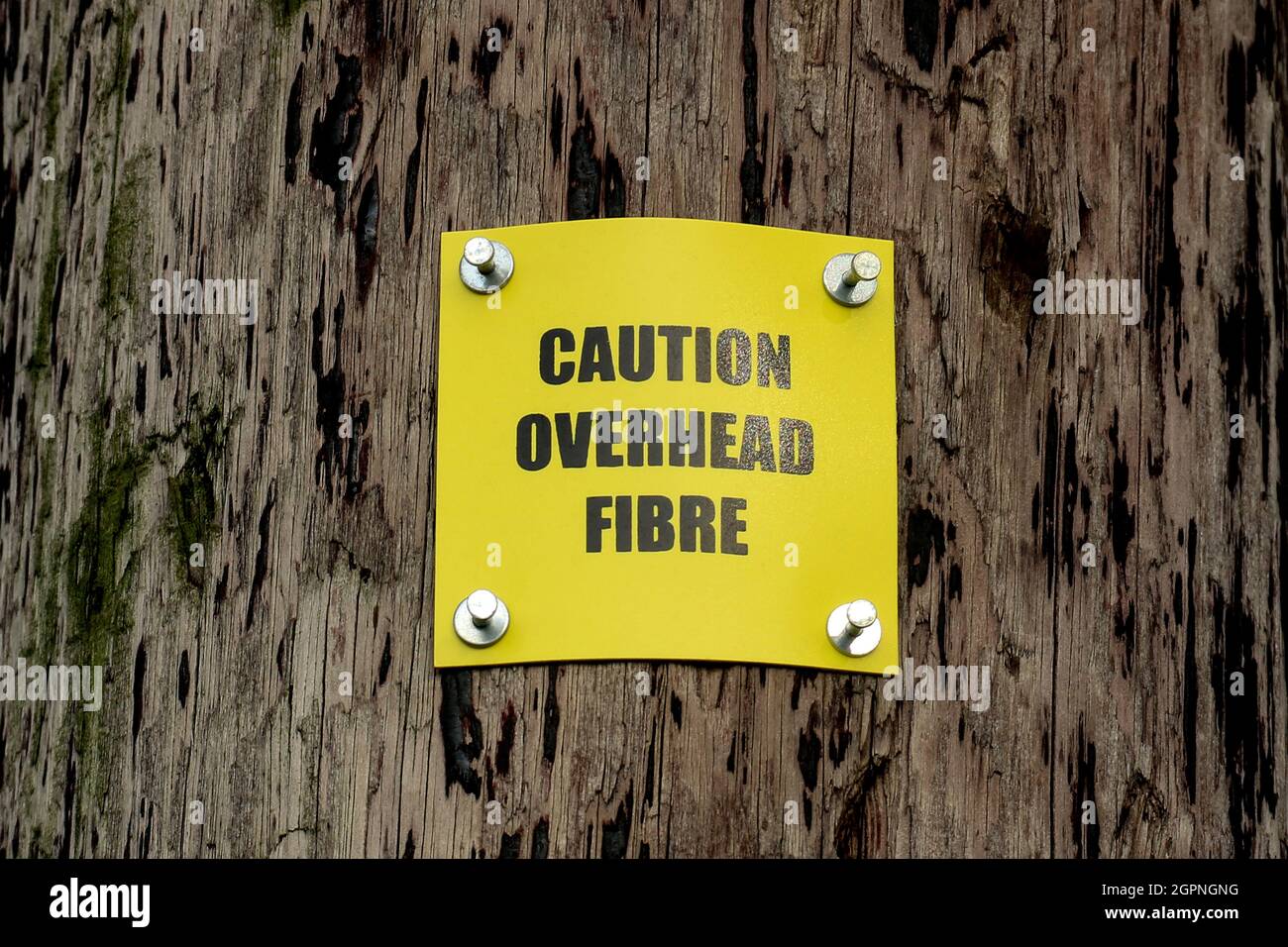 Overhead cables warning sign on a wooden electricity pole Stock Photo ...