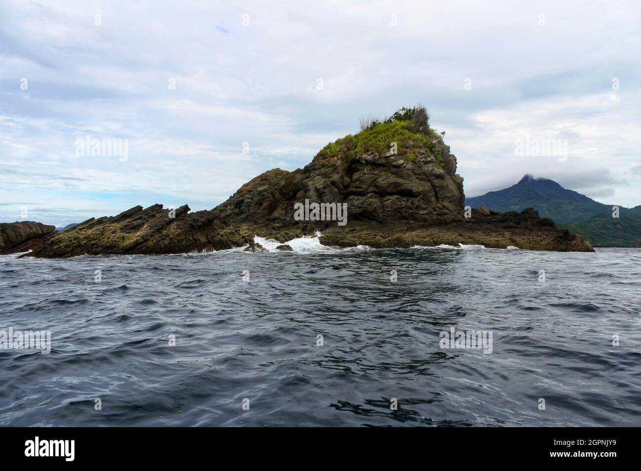 Scenic view of small tropical rock island in middle of sea with ...