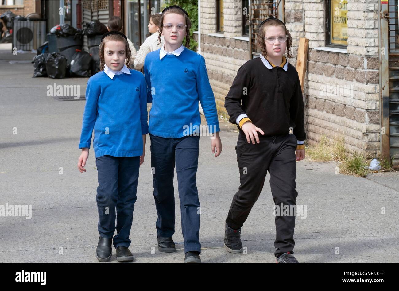 Young Hasidic Jewish boys with long peyus walk together on Lee Avenue ...