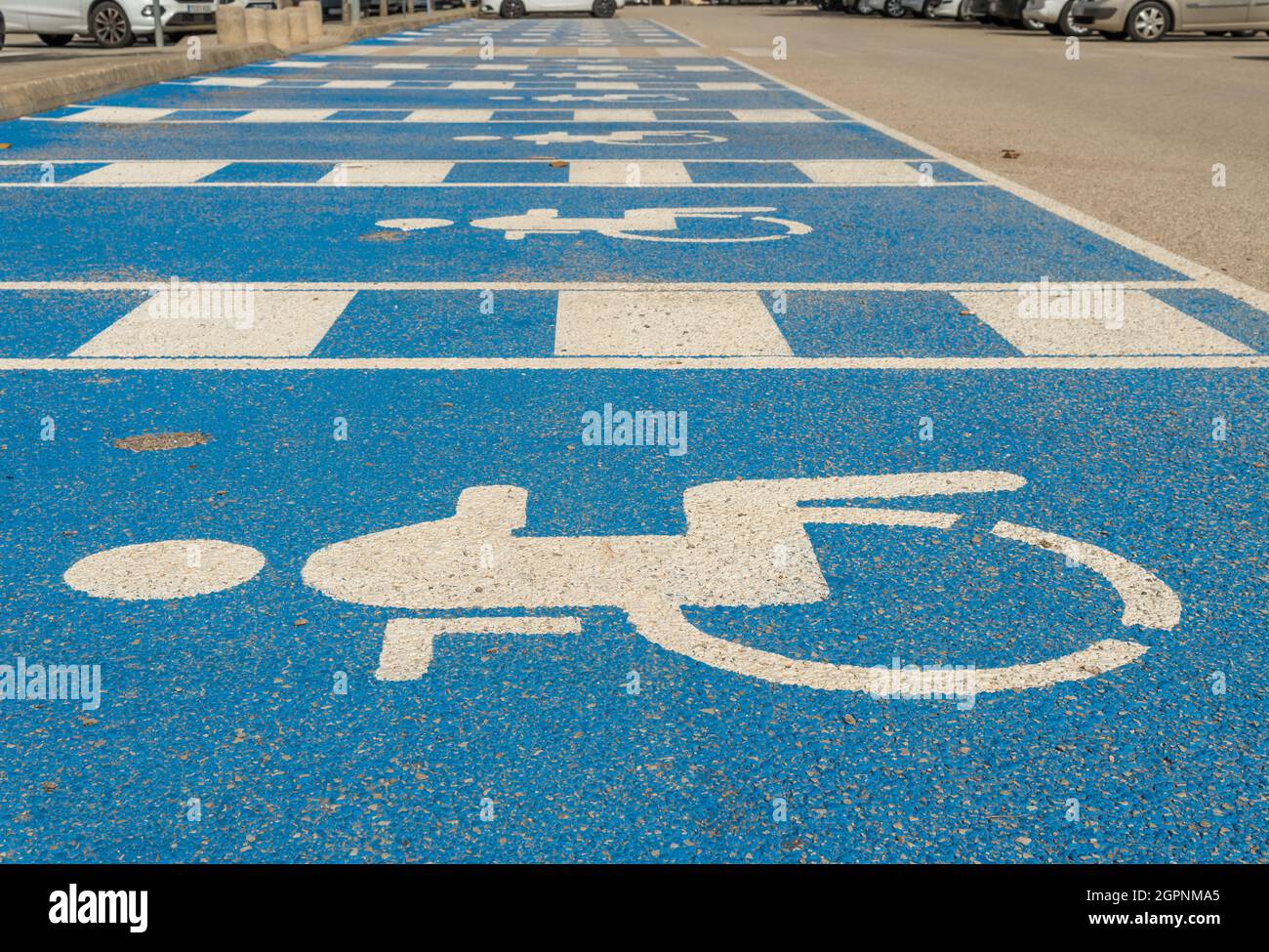 Parking area for disabled people painted in blue and with the symbol of ...