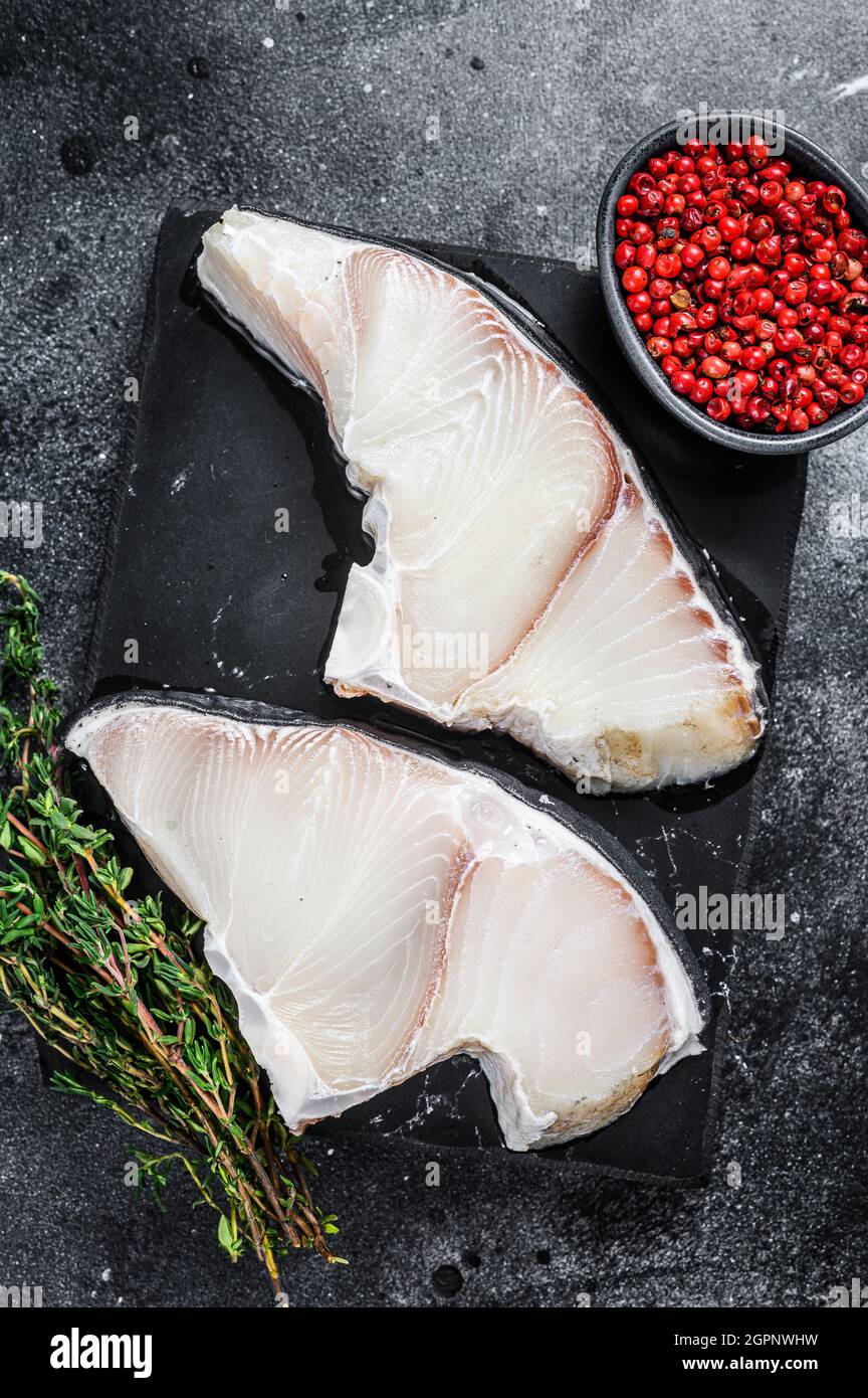 Raw Shark fish steaks on a board. Black background. Top view Stock ...