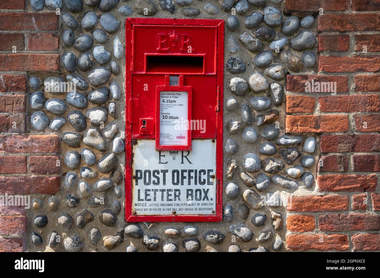 An old ER royal mail red post box set in a flint wall in Norfolk UK ...