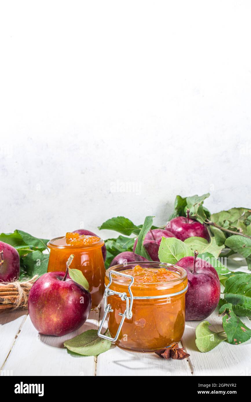 Homemade golden colored apple jam, with farm red apples and leaves on ...