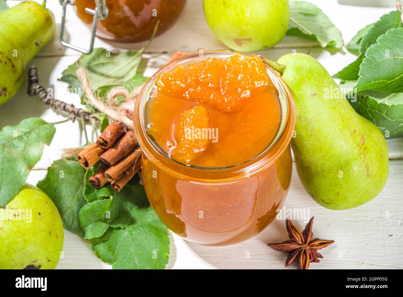 Homemade golden colored pear jam, with farm pears and leaves on white ...