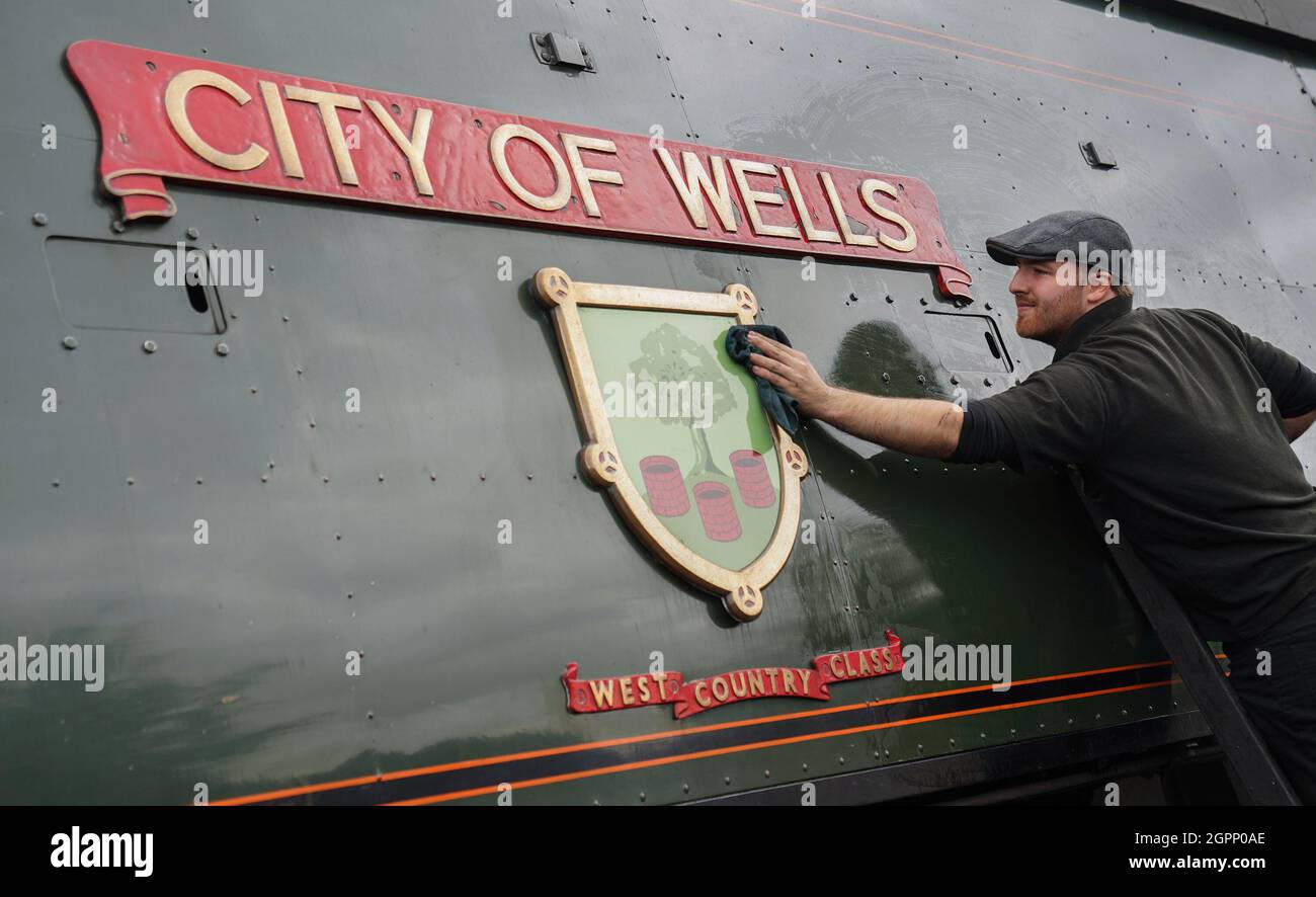 Volunteer Samuel Sharp cleans the side of the steam locomotive 34092 ...