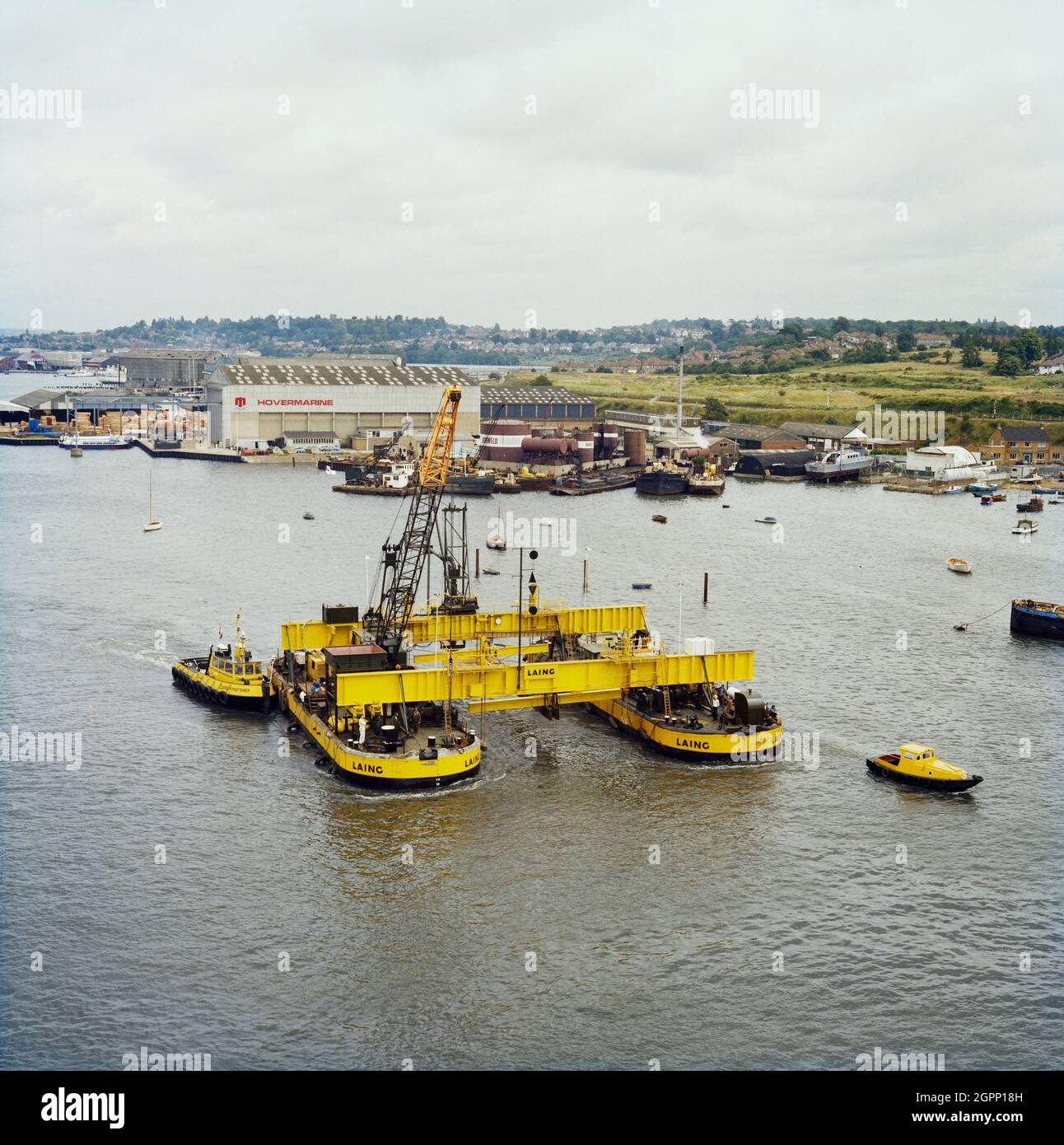A twin hull barge being towed down river from Woolston, Hampshire, for ...