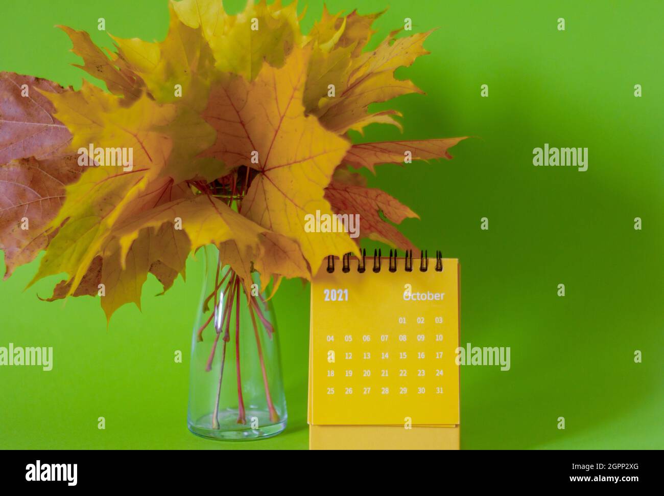 A tear-off calendar for October 2021 and an autumn bouquet of bright ...