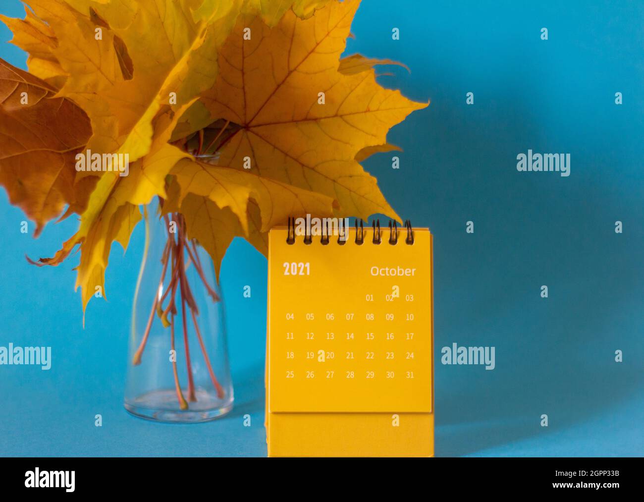 A tear-off calendar for October 2021 and an autumn bouquet of bright ...