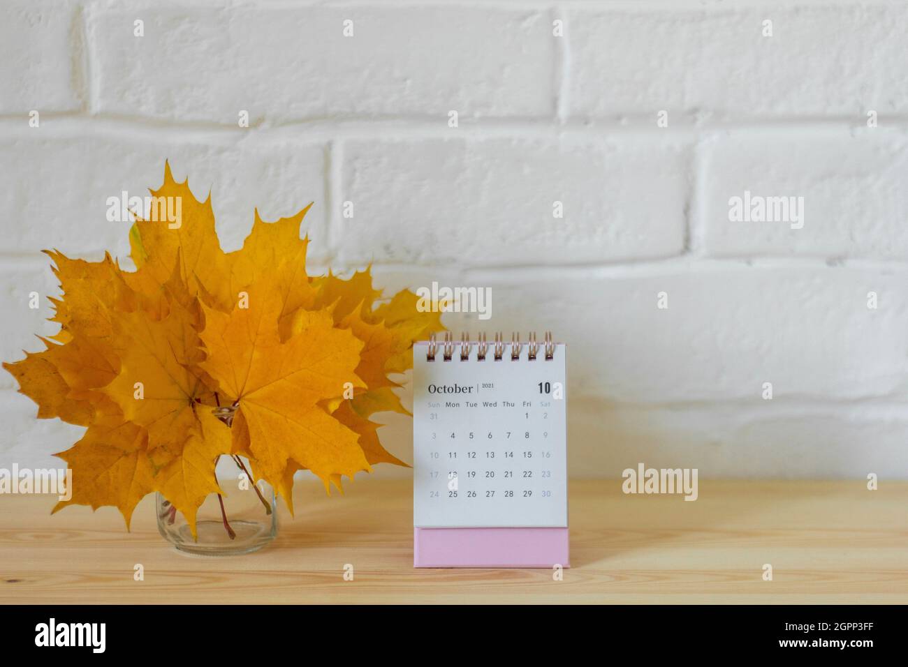 A tear-off calendar for October 2021 and an autumn bouquet of bright ...