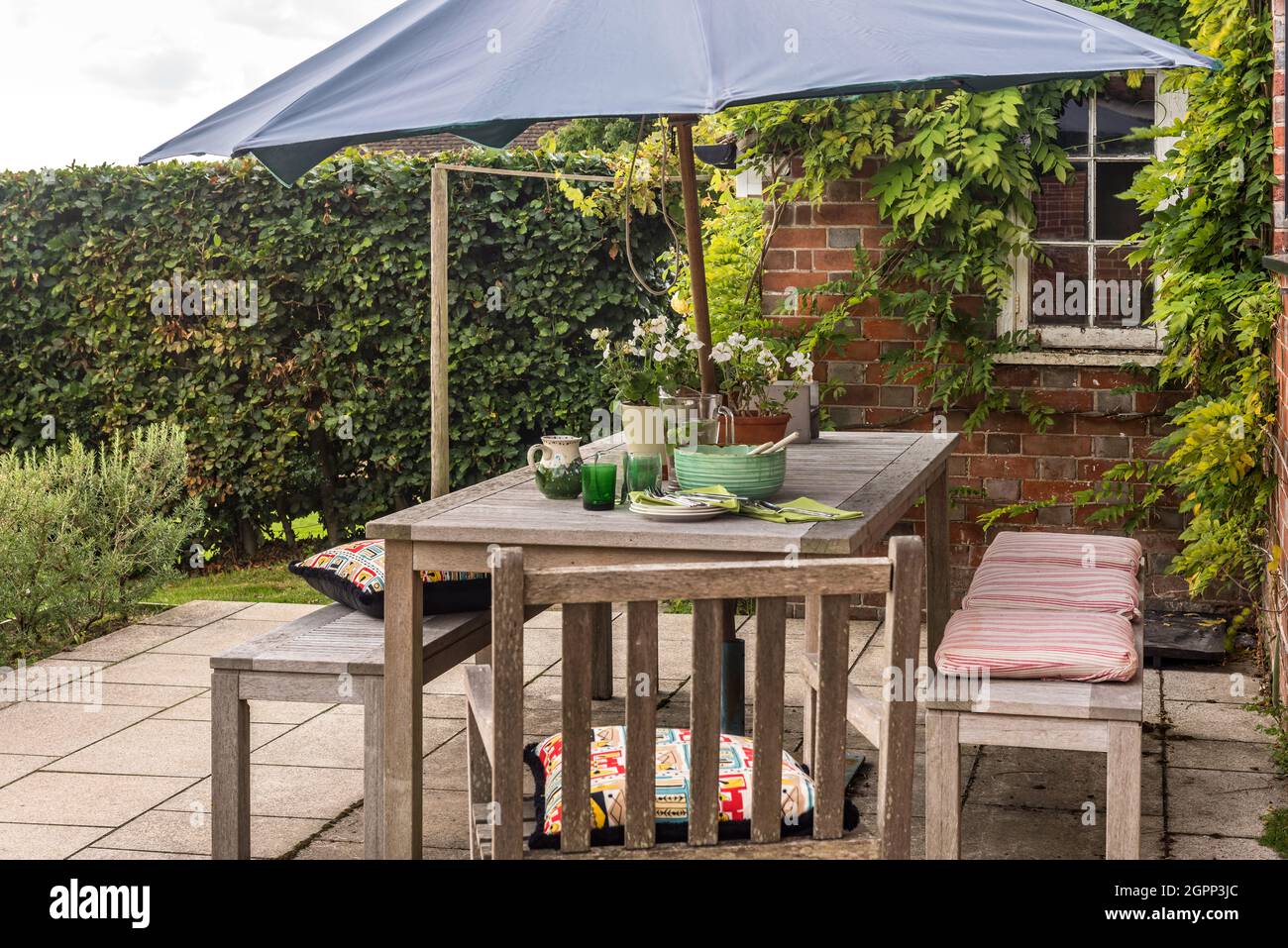 Parasol on terrace with table and benches, Sussex farmhouse, UK Stock ...