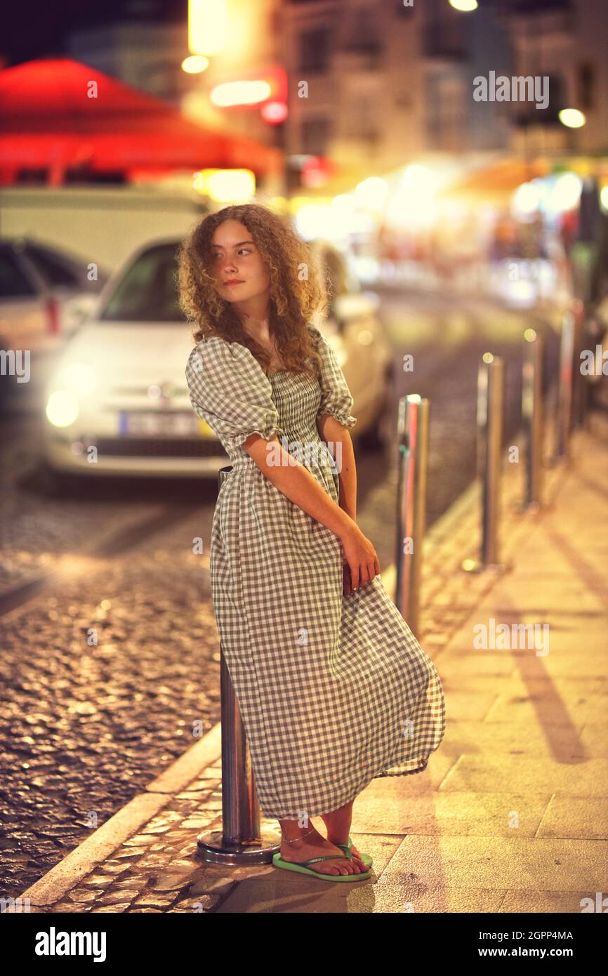 teenage girl in a dress with curly hair at night on the city Stock ...